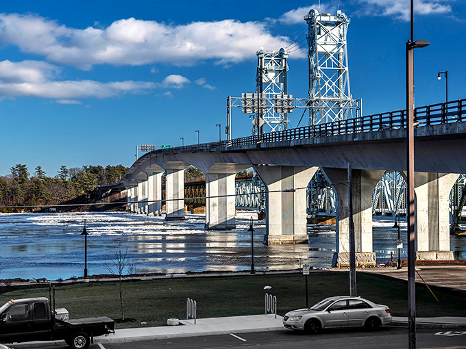 The impressive Sagadahoc Bridge spans the Kennebec River, connecting Bath to neighboring communities under a brilliant blue sky.