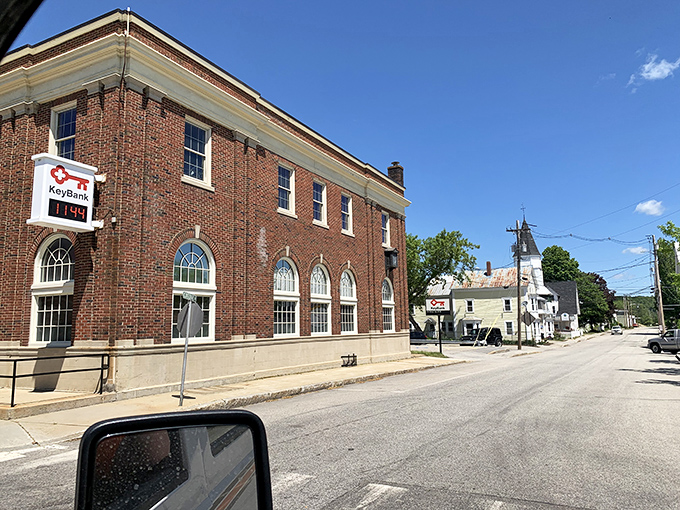 This brick schoolhouse in Norway stands as a testament to the town's history, with playground equipment visible behind the fence.