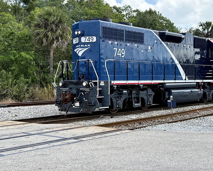 The powerful blue Amtrak locomotive #749 waits on the tracks, ready to continue its journey through Florida's scenic landscapes and historic small towns.
