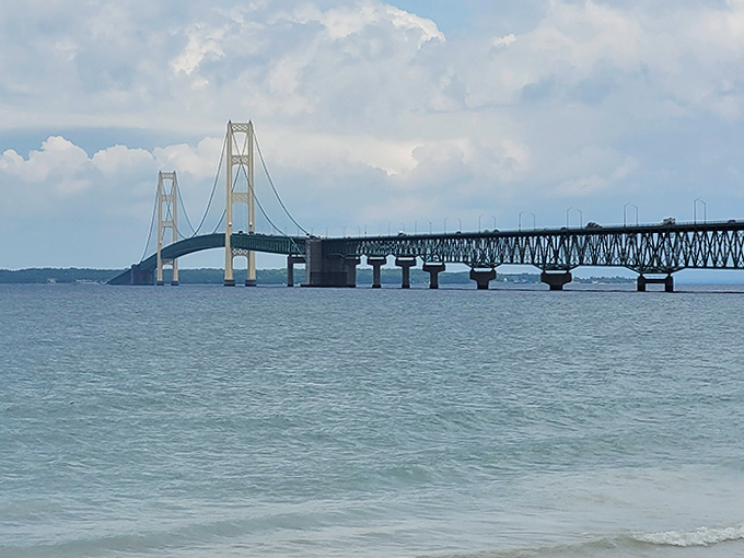 Where water meets sky, the Mackinac Bridge creates a perfect dividing line, its elegant profile etched against Michigan's boundless blue horizon.