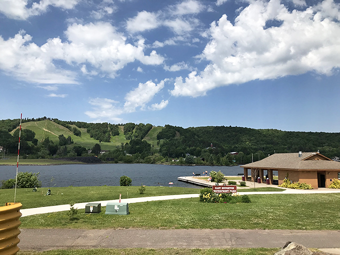 East Houghton Waterfront Park transforms into a community gathering spot during summer, with boats bobbing gently against the backdrop of hills.