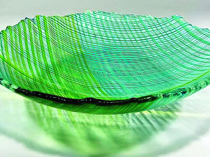 Like a frozen wave of emerald sea, this textured glass bowl captures light and imagination with equal brilliance.