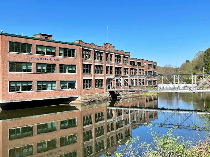 The Springfield Health Center overlooks waters that once powered an industrial empire, now reflecting peaceful progress.