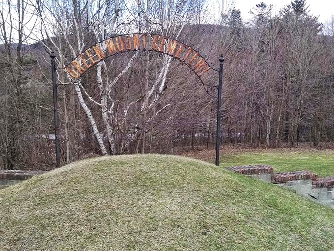 "Green Mountain View" reads this rustic archway, marking a peaceful corner where Vermont's rolling landscape cradles eternal rest.