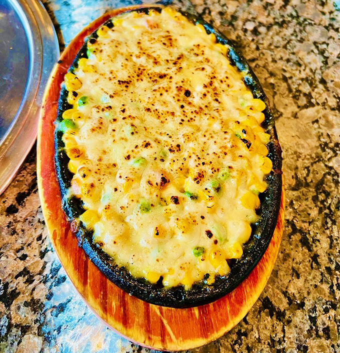 Korean Corn Cheese bubbles with golden perfection &ndash; a sizzling skillet of sweet corn beneath a blanket of melted cheese that stretches with each heavenly bite.