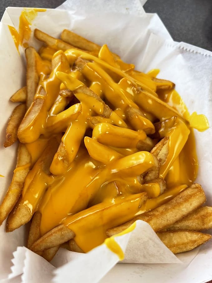 Golden fries drowning in gloriously artificial cheese sauce, because sometimes fancy isn't what you need, just delicious.