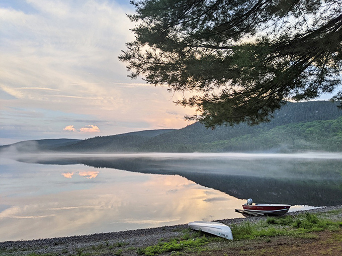 Dawn's golden promise spreads across still waters, while boats wait patiently for their day to begin.
