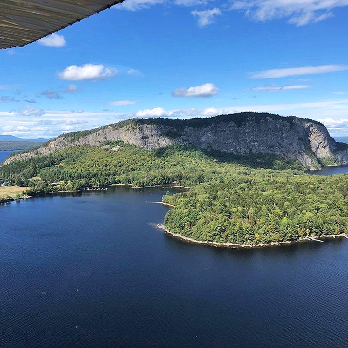 Mount Kineo's dramatic cliff face commands attention across the water, daring hikers to discover its summit views that reward every step.