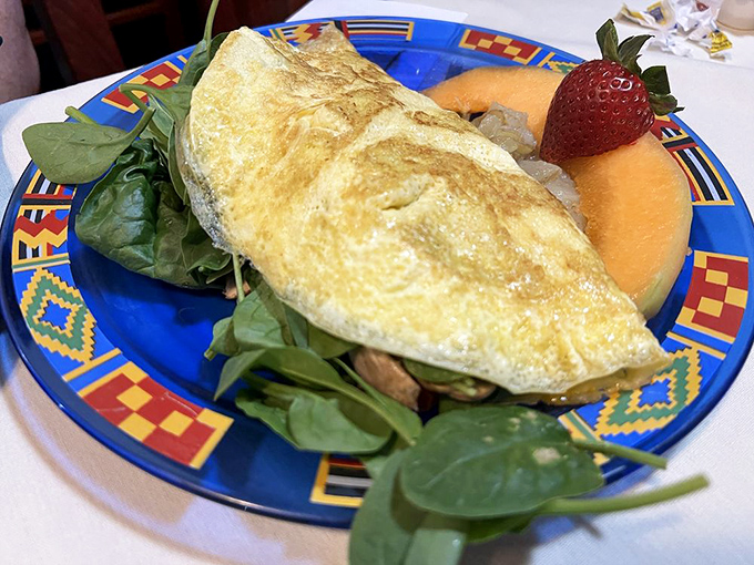 This isn't just any omelet &ndash; it's a fluffy masterpiece accompanied by fresh spinach and fruit, proving breakfast can be both beautiful and delicious.