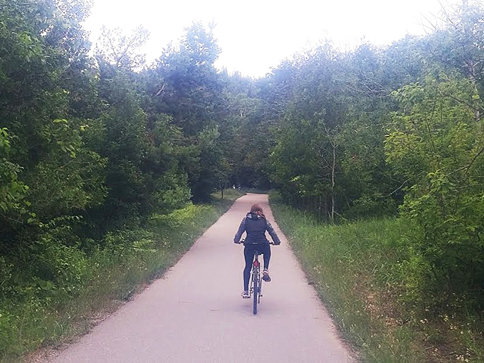 Cyclists and walkers enjoy the paved Sleeping Bear Heritage Trail, where forest shade provides welcome relief on hot summer days.