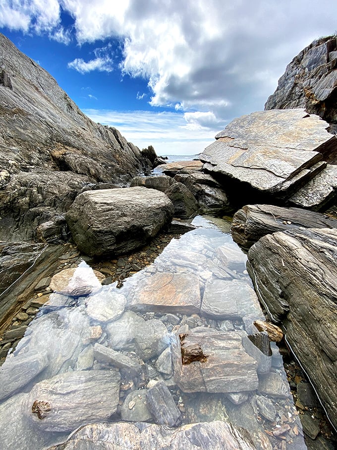 Nature's infinity pool: crystal-clear tide pools nestled between massive rock formations offer glimpses into miniature underwater worlds.