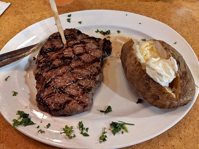 Steak perfection doesn't need fancy words. This beautifully grilled masterpiece with a loaded baked potato on the side speaks the universal language of "get in my belly."
