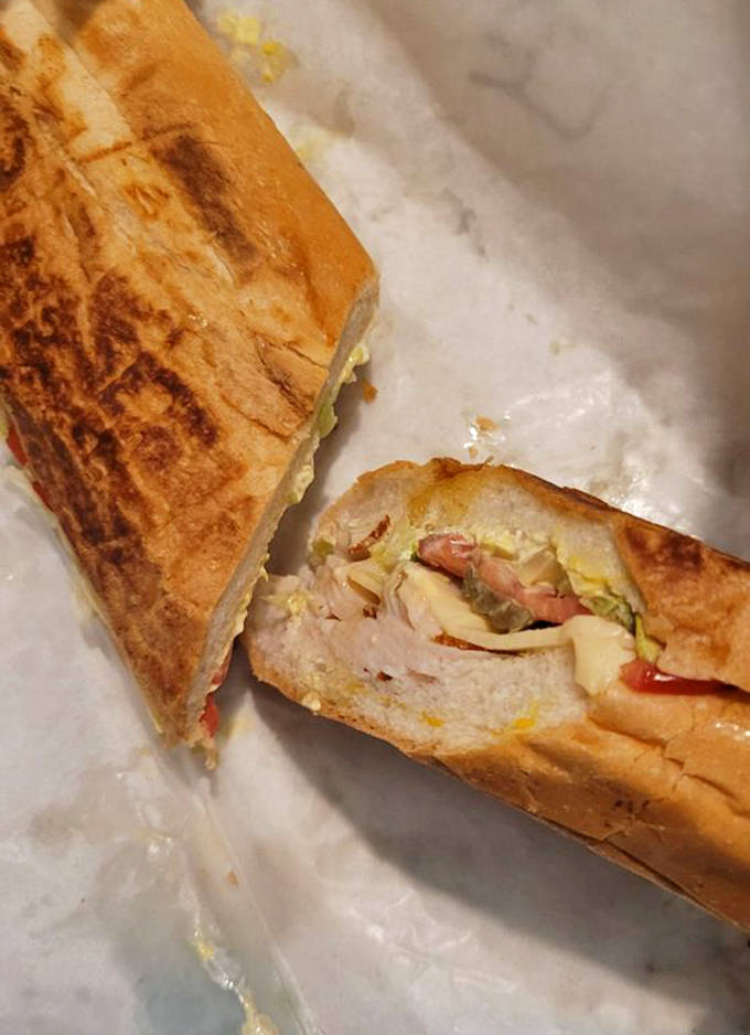 The Tampa Cuban in all its pressed glory &ndash; layers of ham, roasted pork, Swiss cheese, pickles, and mustard creating perfect harmony between crispy bread.