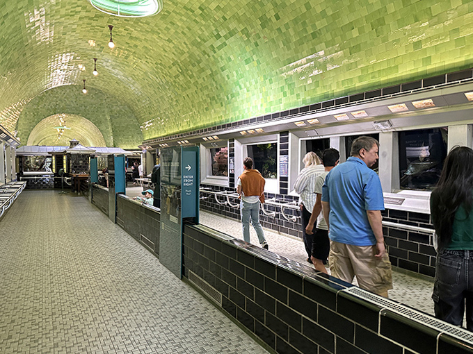 Visitors explore the historic corridor where black tiles and vintage fixtures transport you to 1904, minus the uncomfortable fashion choices.