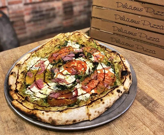 Wood-Fired Pizza: A symphony of colors and textures – the pesto base creates a verdant canvas for fresh mozzarella and heirloom tomatoes.