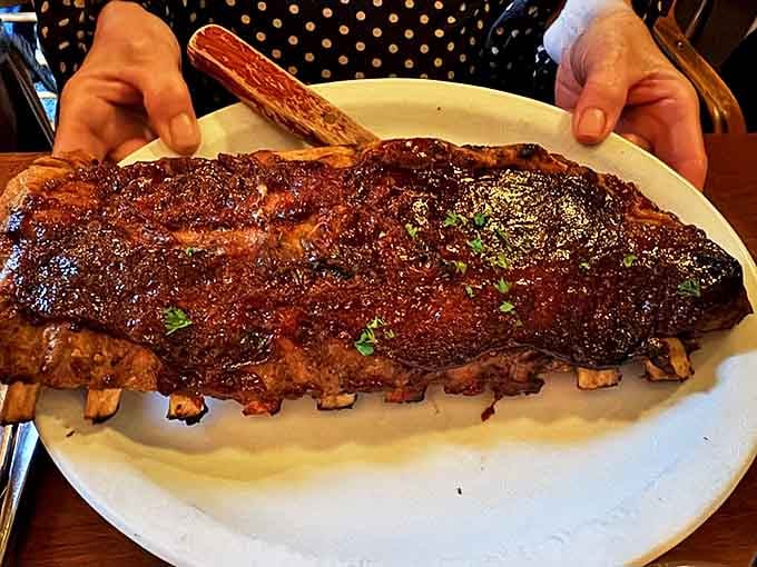 These barbecue ribs don't just fall off the bone – they practically leap onto your fork, their caramelized glaze glistening under soft lighting.