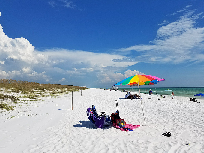 Rainbow umbrella dreams: The perfect beach day unfolds under Florida's endless blue sky, where worries melt faster than ice cream.