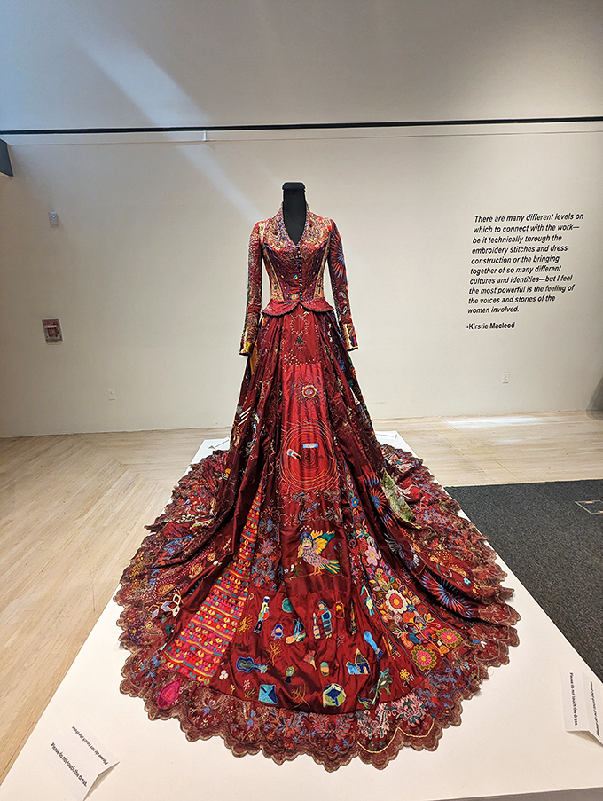 A stunning red ceremonial gown stands proudly on display, its intricate embroidery telling stories through thousands of careful stitches.