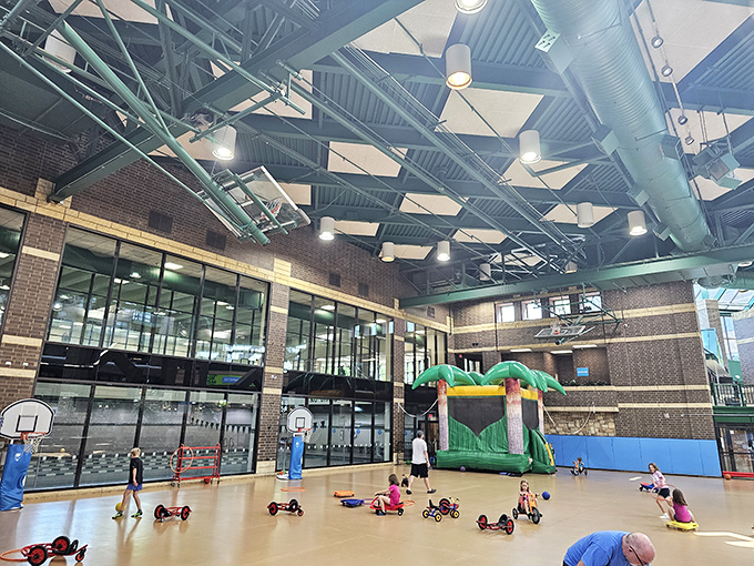 Colorful ride-on toys scatter across the floor like a toddler demolition derby waiting to happen, supervised chaos at its finest.