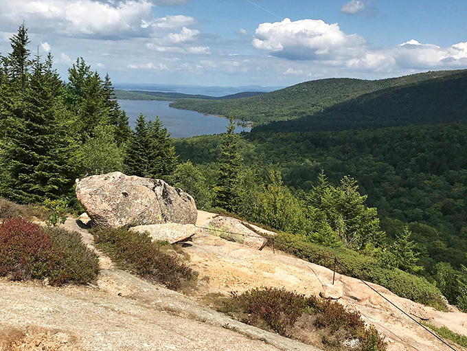 Jordan Pond glistens below like nature's mirror, reflecting clouds and surrounding mountains in a display that puts Instagram filters to shame.