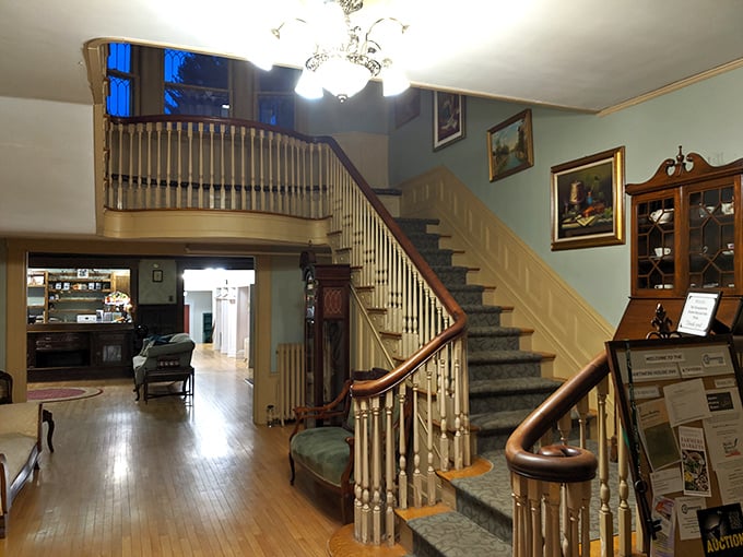A grand staircase curves upward, leading to guest rooms that blend historic charm with modern comforts.