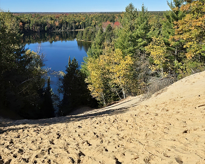 Sandy slopes cascade toward blue waters below, creating a natural stairway that practically begs you to kick off your shoes and run down.