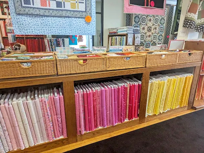 Wicker baskets overflow with color-coordinated fabrics, arranged like edible treats in a confectionery of cotton delights for eager quilters.