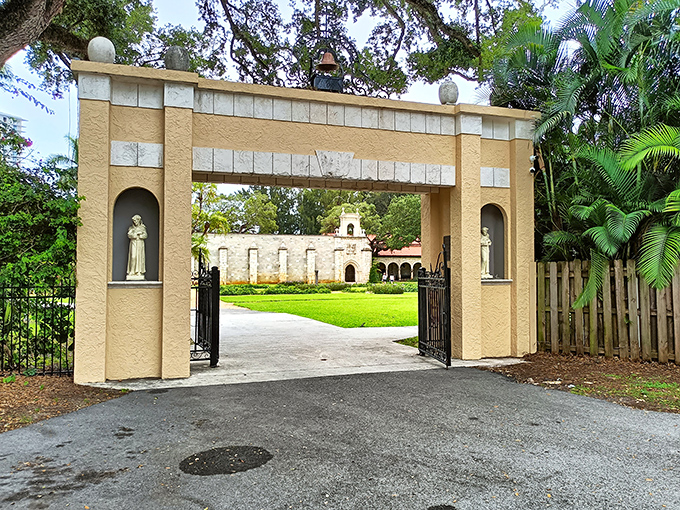 The Ancient Spanish Monastery's grand entrance stands as a portal to another time, its stone archway framing the historic buildings beyond.