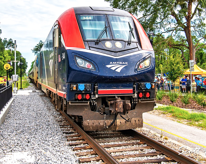 Amtrak's sleek modern train #344 glides into the station, its aerodynamic design catching the eye of excited families preparing to board for their affordable Florida adventure.
