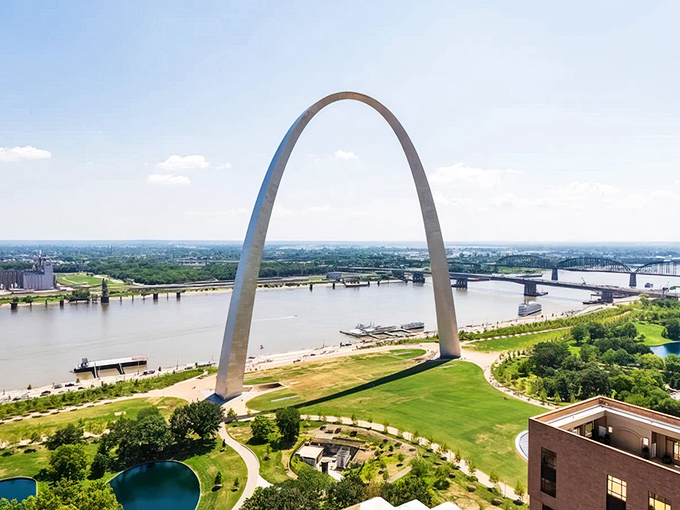 St. Louis's gleaming Gateway Arch creates a perfect silver rainbow against the blue Missouri sky, visible for miles around.