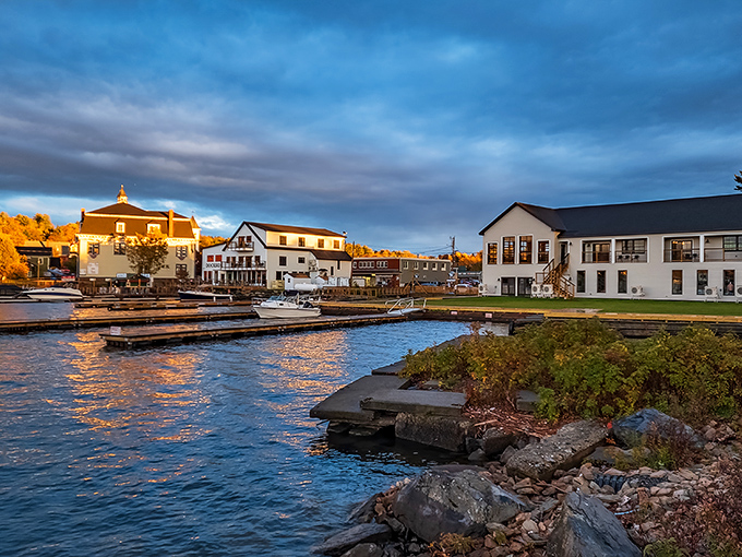 Greenville's waterfront buildings reflect in the mirror-like waters at sunset, creating a magical golden glow across the harbor.