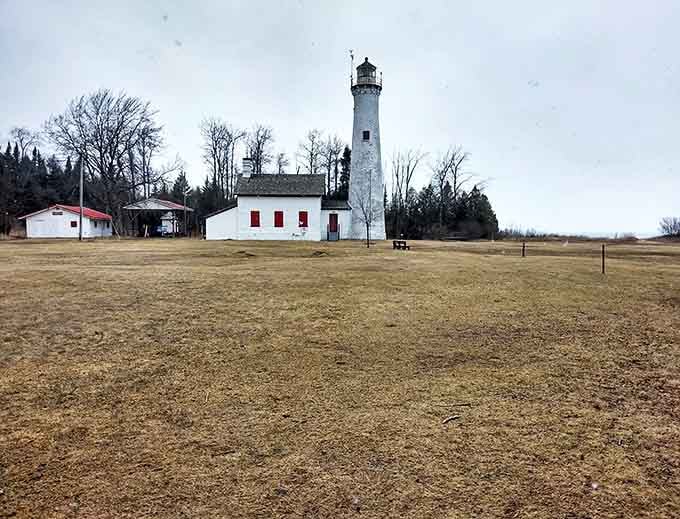 Harrisville's lighthouse stands sentinel against stormy skies, a reminder of Lake Huron's power and maritime history.