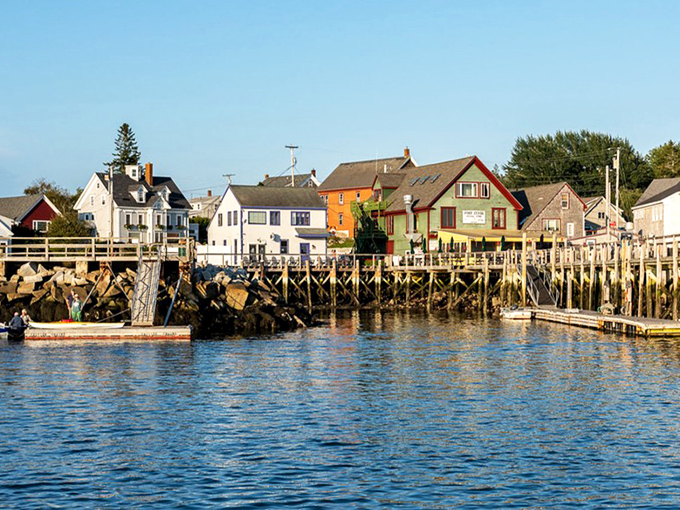 Port Clyde's working waterfront features colorful buildings perched on wooden piers, where fishing boats unload the day's catch.