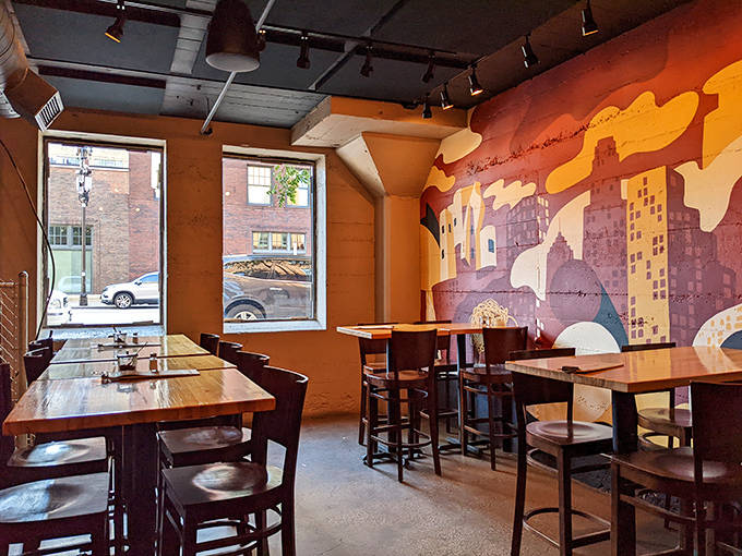 Wooden tables and an eye-catching cityscape mural transform Black Sheep's industrial space into a warm, inviting pizza destination.
