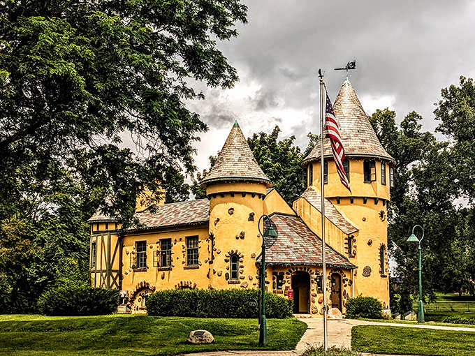 The storybook castle stands proudly with its American flag, colorful embedded stones adding playful character to this writer's former sanctuary.