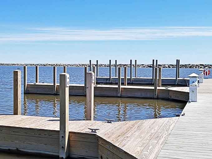 Wooden docks reach into calm harbor waters, offering boaters a safe haven and visitors a perfect sunset-watching perch.