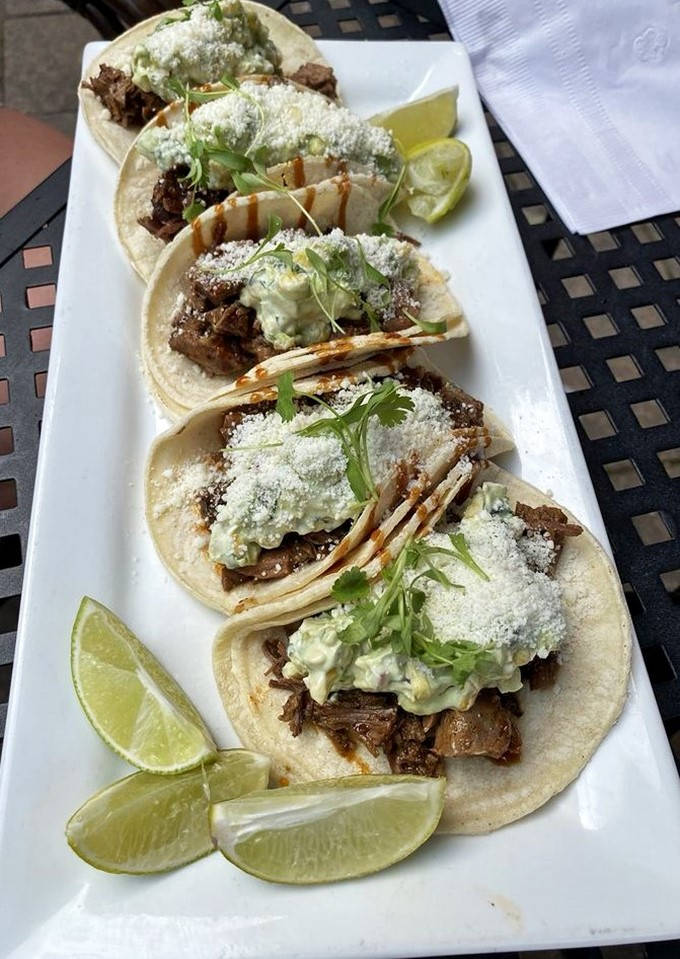 These aren't just tacos; they're little hand-held masterpieces where tender brisket meets creamy sauce and a shower of cotija cheese.