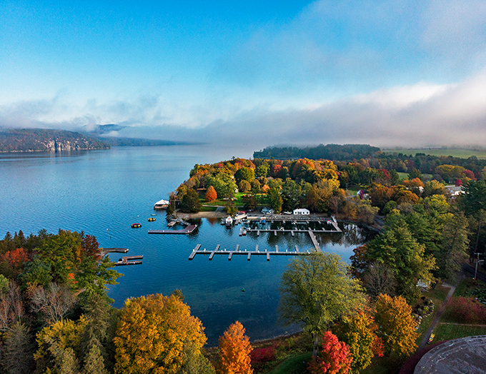 Basin Harbor offers a quintessential Vermont lake experience, where boats bob gently against the backdrop of autumn's fiery display.