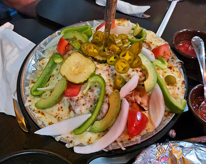 Fresh avocado, tomatoes, and jalape&ntilde;os crown this sizzling dish, bringing vibrant color and flavor to the traditional preparation.