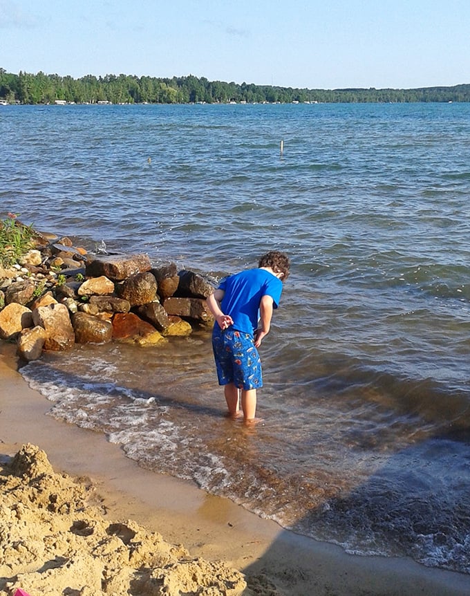 Childhood wonder unfolds at the water's edge, where simple pleasures like splashing in shallows create lifelong memories.