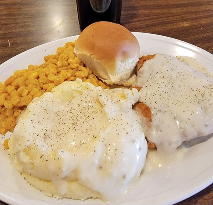 Chicken fried steak smothered in peppery white gravy cascading onto fluffy mashed potatoes &ndash; comfort food that hugs you from the inside out.