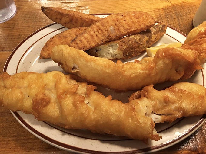 The cod dinner arrives golden and flaky, with those ridged potato wedges that somehow manage to be both crispy and fluffy.