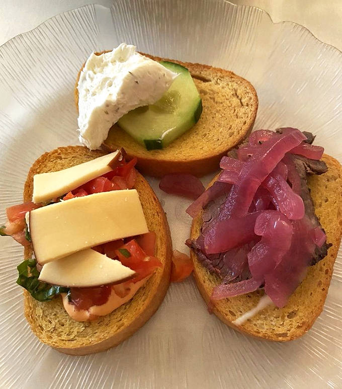 These artful crostini showcase the kitchen's attention to detail &ndash; one topped with fresh cheese and cucumber, another with tomato, and a third with beef and pickled onions.