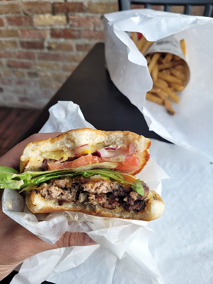 A burger that requires both hands and a strategy &ndash; juicy patty, fresh toppings, and a bun that somehow manages to contain this beautiful chaos.