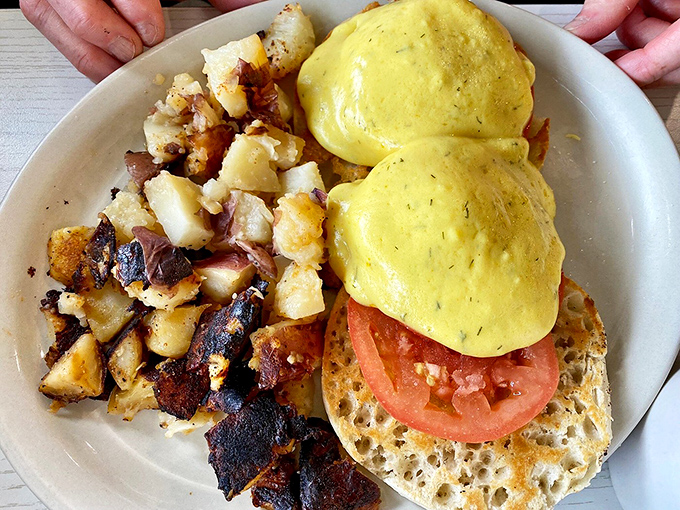 Eggs Benedict done right, with perfectly poached eggs, creamy hollandaise, and home fries so good they deserve their own fan club and possibly a parade.