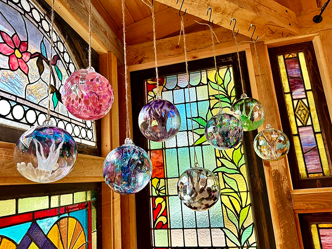 Handblown glass ornaments catch light from every angle, creating miniature galaxies of color suspended from rustic beams.
