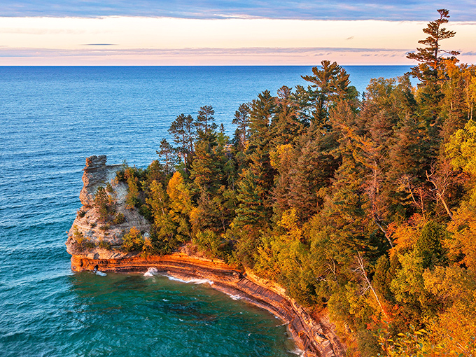 Autumn transforms Hollow Rock Cove into a painter's palette of oranges and reds, perfectly framing Lake Superior's eternal blue canvas.