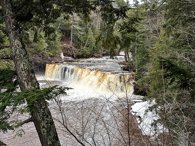 Manabezho Falls thunders with primal power, sending up a misty spray that turns sunlight into impromptu rainbows for lucky visitors.