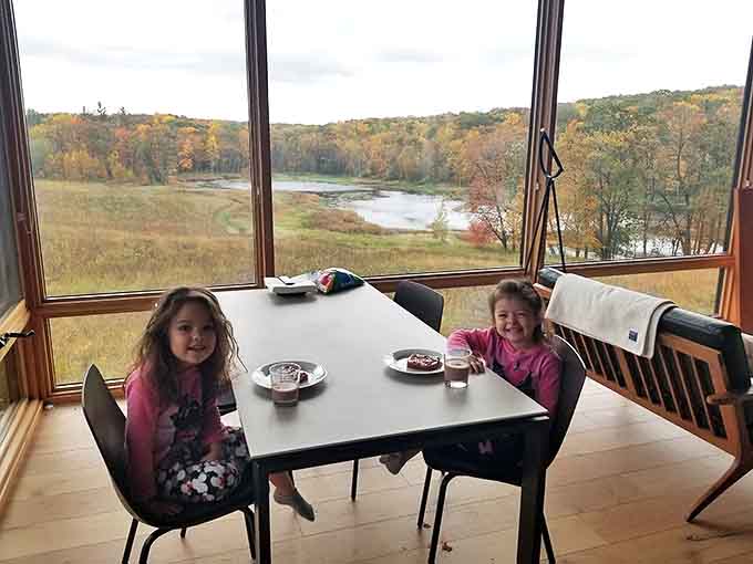 Two young visitors at the dining table prove that even kids can appreciate a room with a view, especially when that view includes more trees than screens.