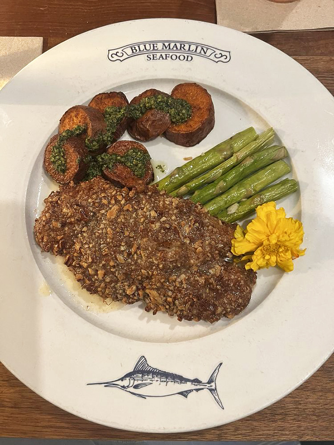 The Pecan Grouper arrives like edible artwork &ndash; nutty crust giving way to flaky fish, with vibrant asparagus and a cheerful marigold garnish.